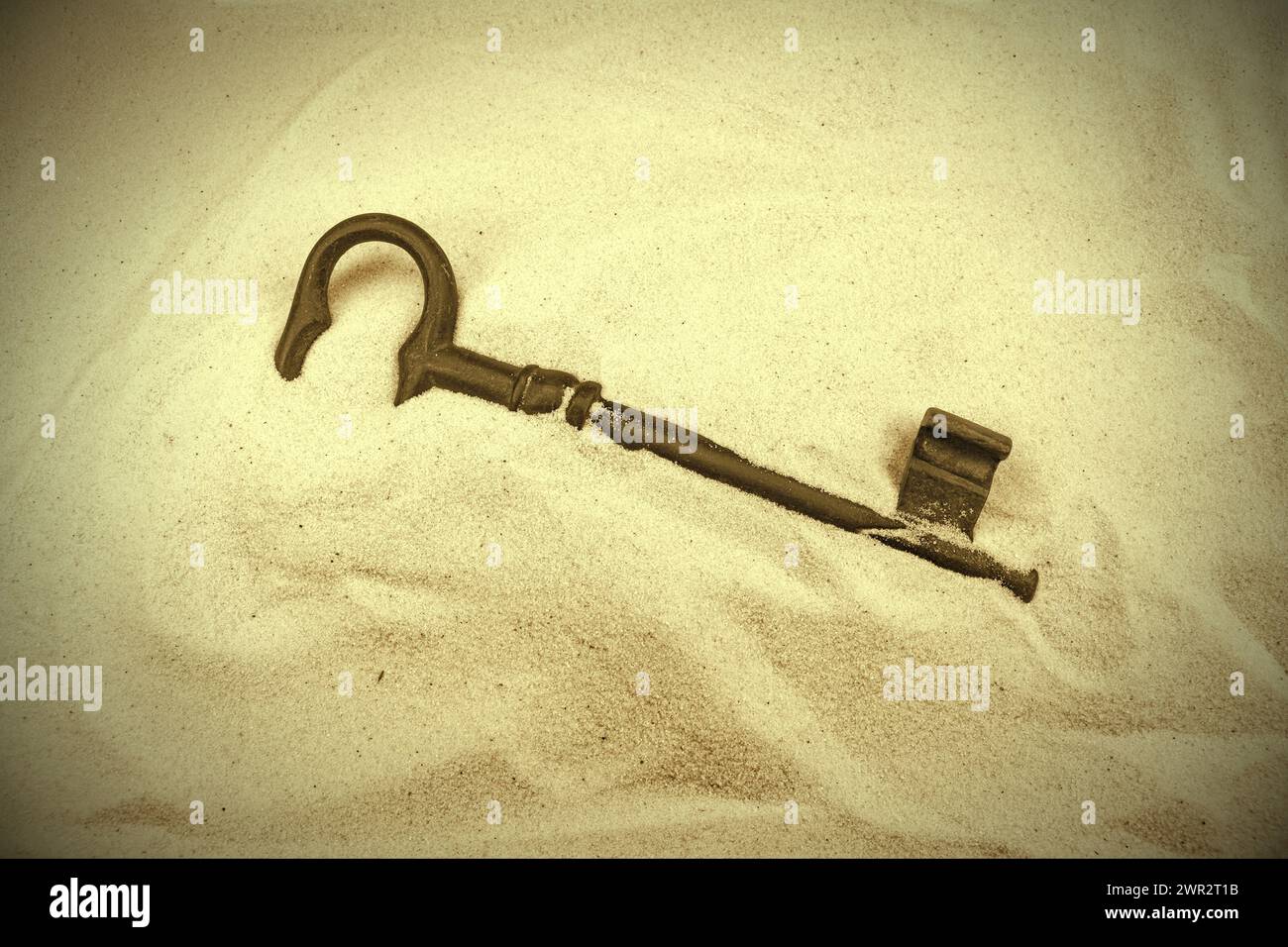 Unlock your future. Old vintage key on the sand. Forgotten, unwanted ...