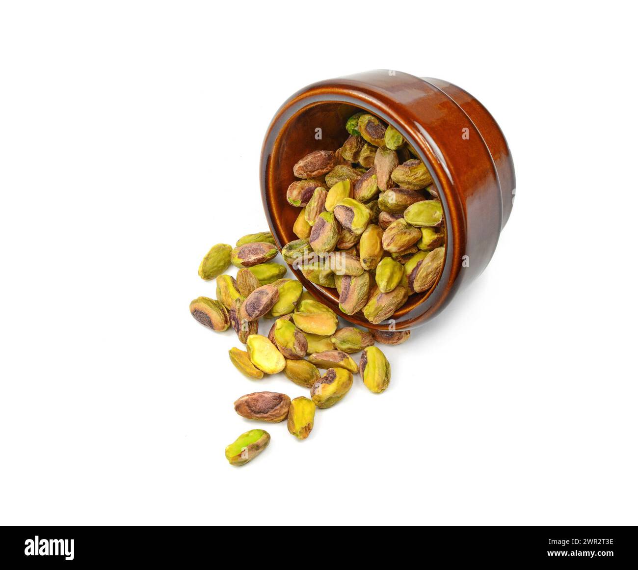 Pistachios spill out of the bowl. Unsalted pistachio nuts Isolated on ...