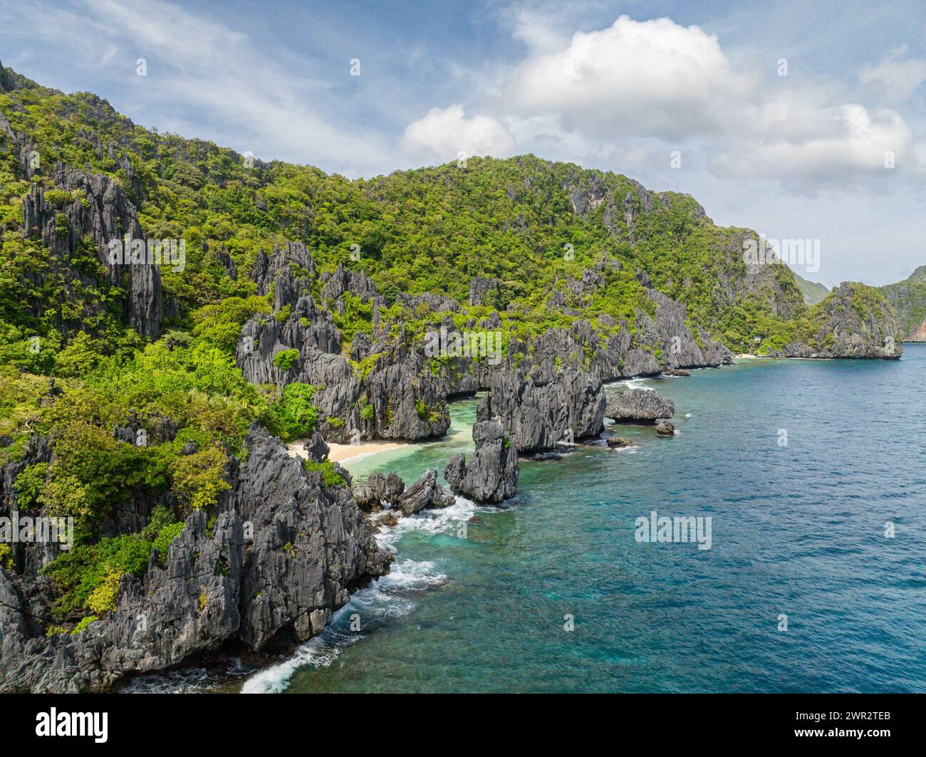Limestone rocks with ocean waves in Matinloc Island. El Nido ...
