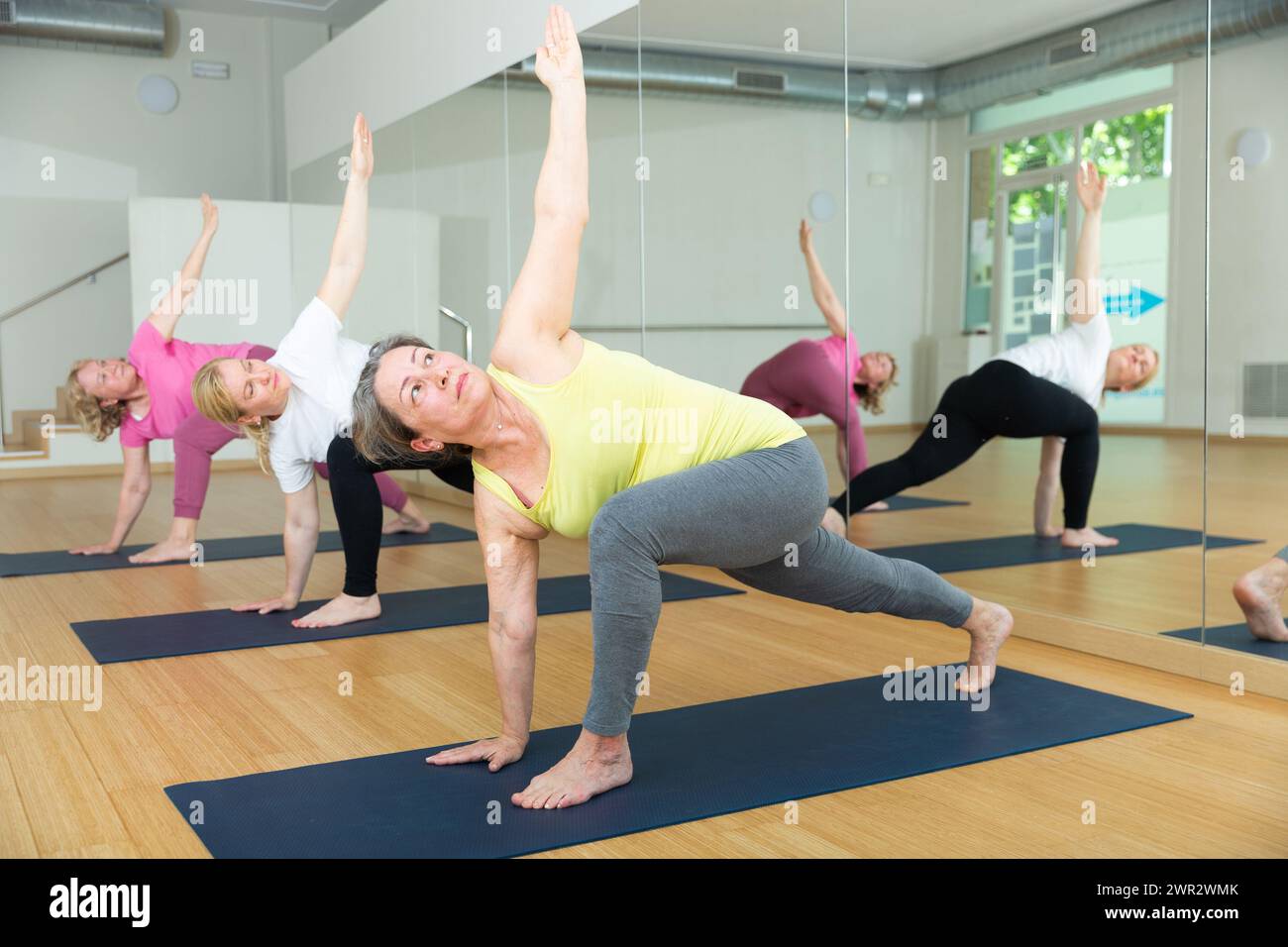 Women are doing extended angle pose Stock Photo - Alamy