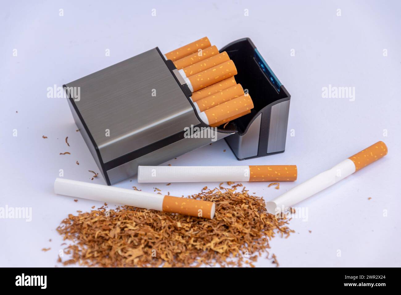 Cigarette case next to scattered smoking tobacco and empty cigarette ...