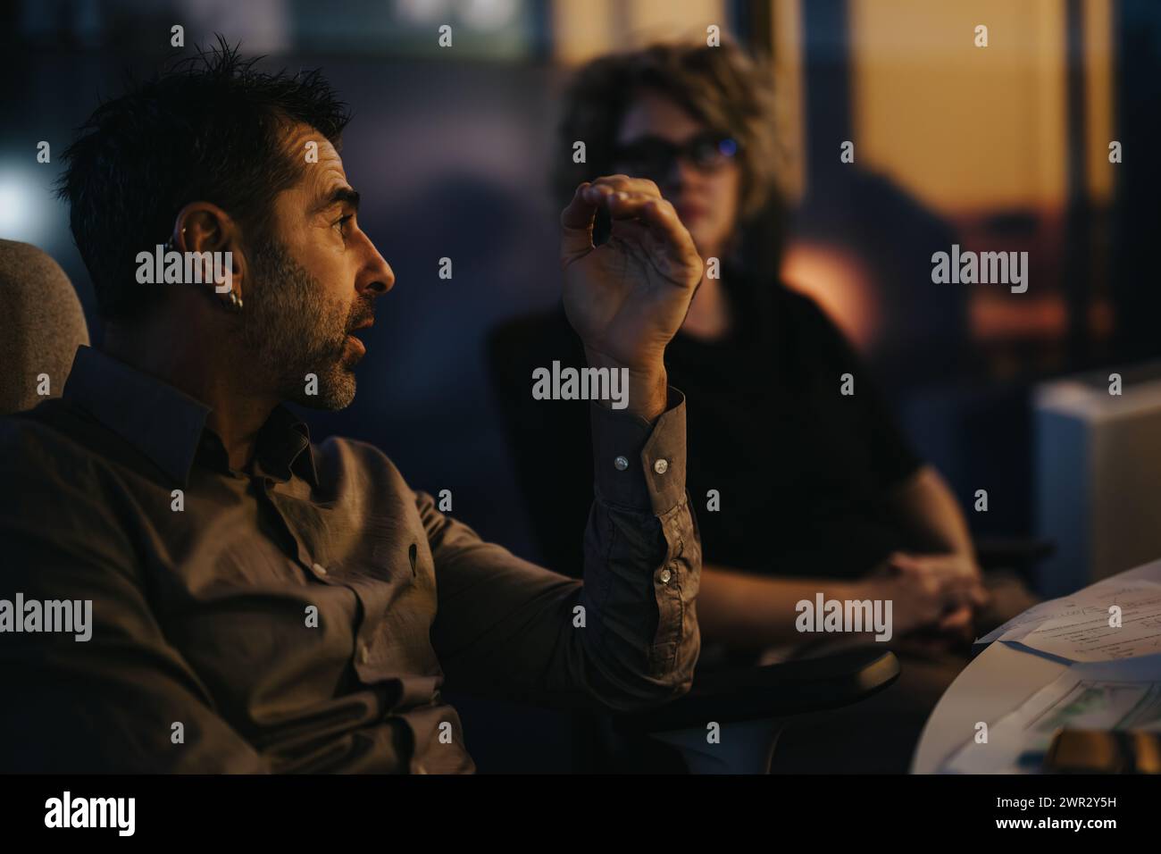 Successful business people collaborating and strategizing in an evening ...