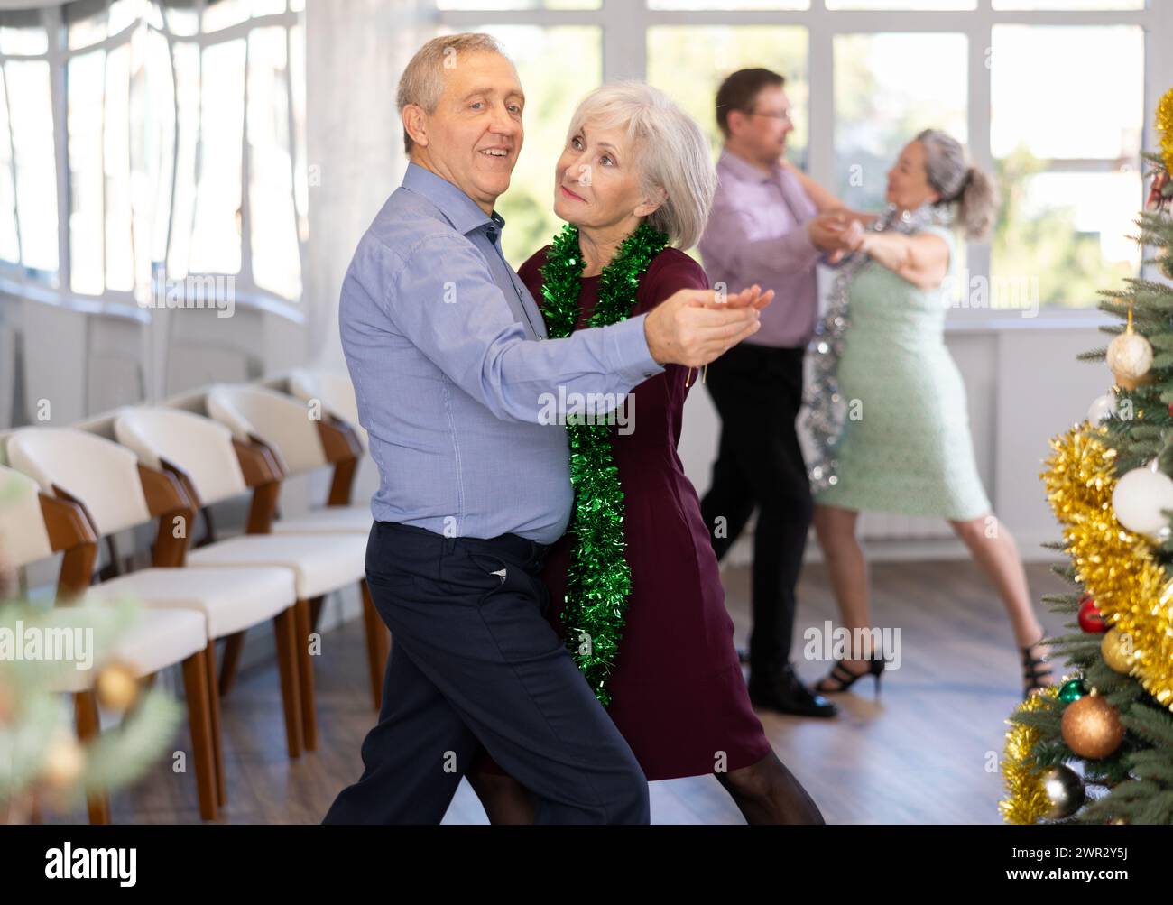 Active elderly people celebrating Christmas and dancing tango in ...