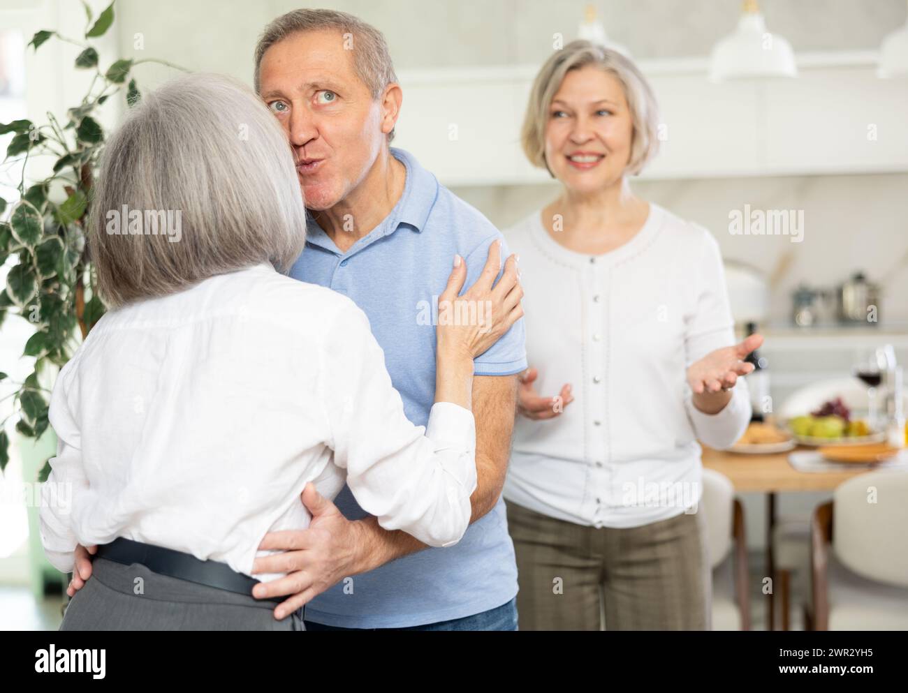 After chatting and gatherings, mature woman hug and kiss goodbye with ...