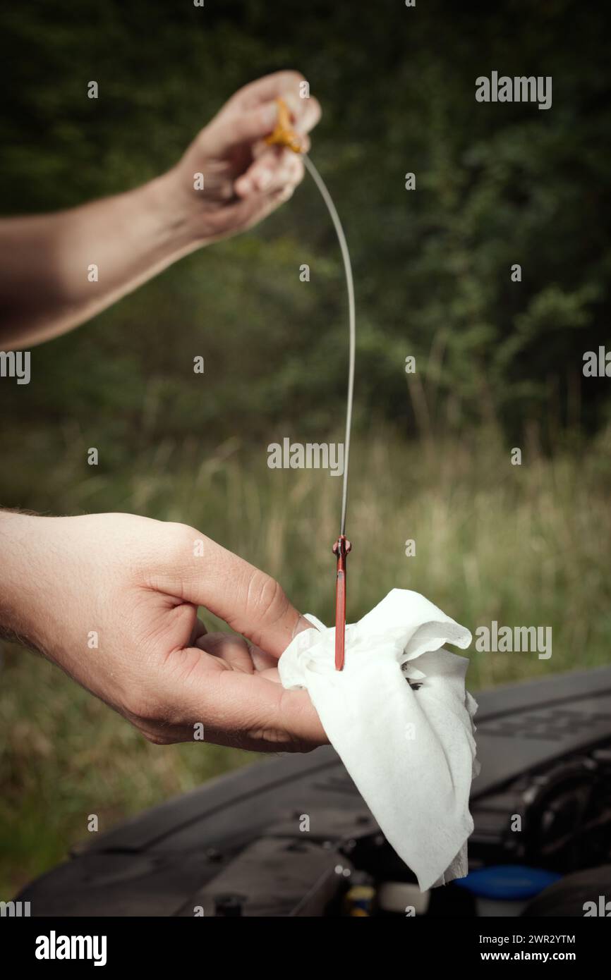 Car driver take care of his car before longer trip and checking oil ...