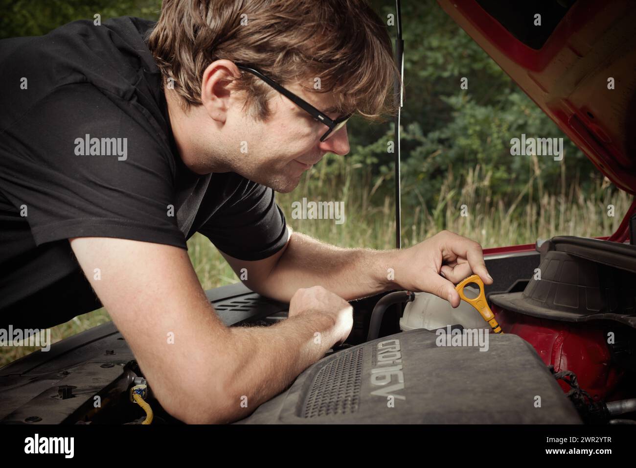 Car driver take care of his car before longer trip and checking oil ...