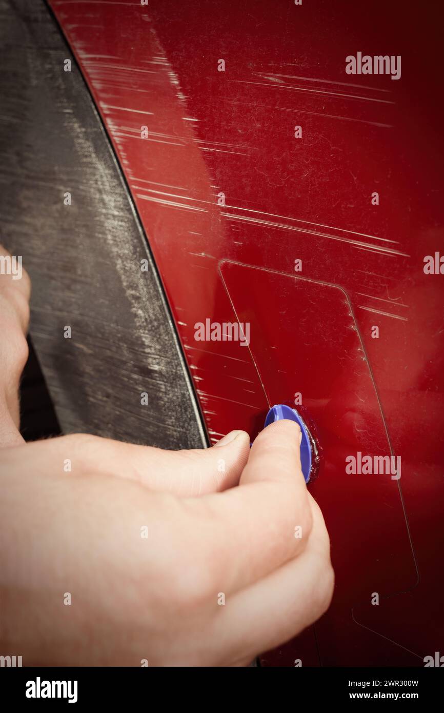 Car owner working on a dent repair with reverse hammer and glue Stock ...