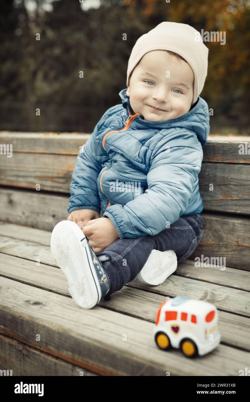 Little boy in autumn park posing for portrait on wooden bench Stock ...