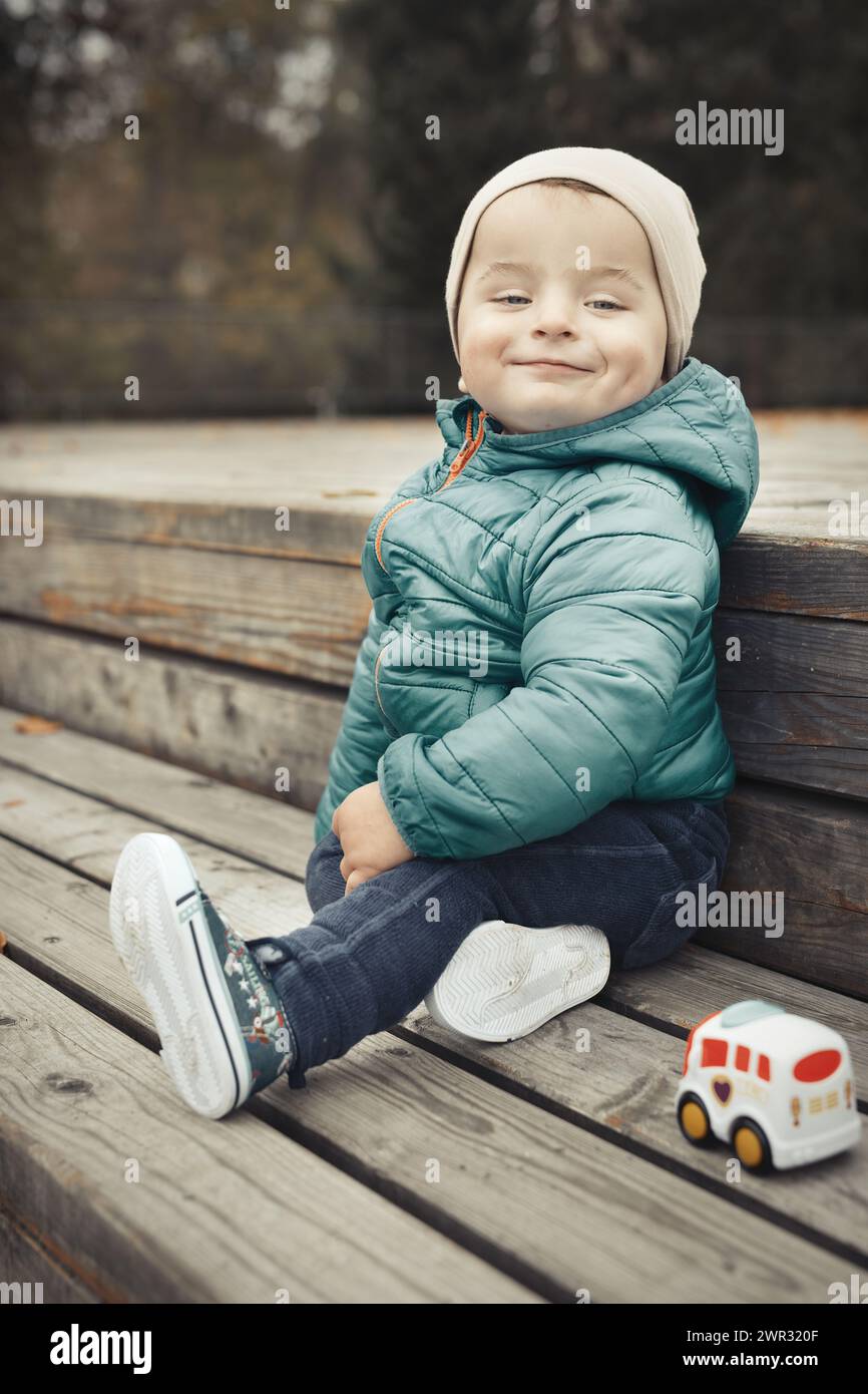 Little boy in autumn park posing for portrait on wooden bench Stock ...