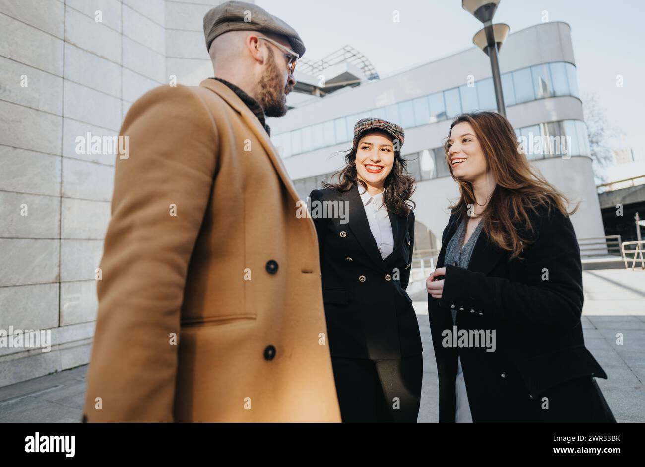 Young people engage in a lively conversation outside modern office ...