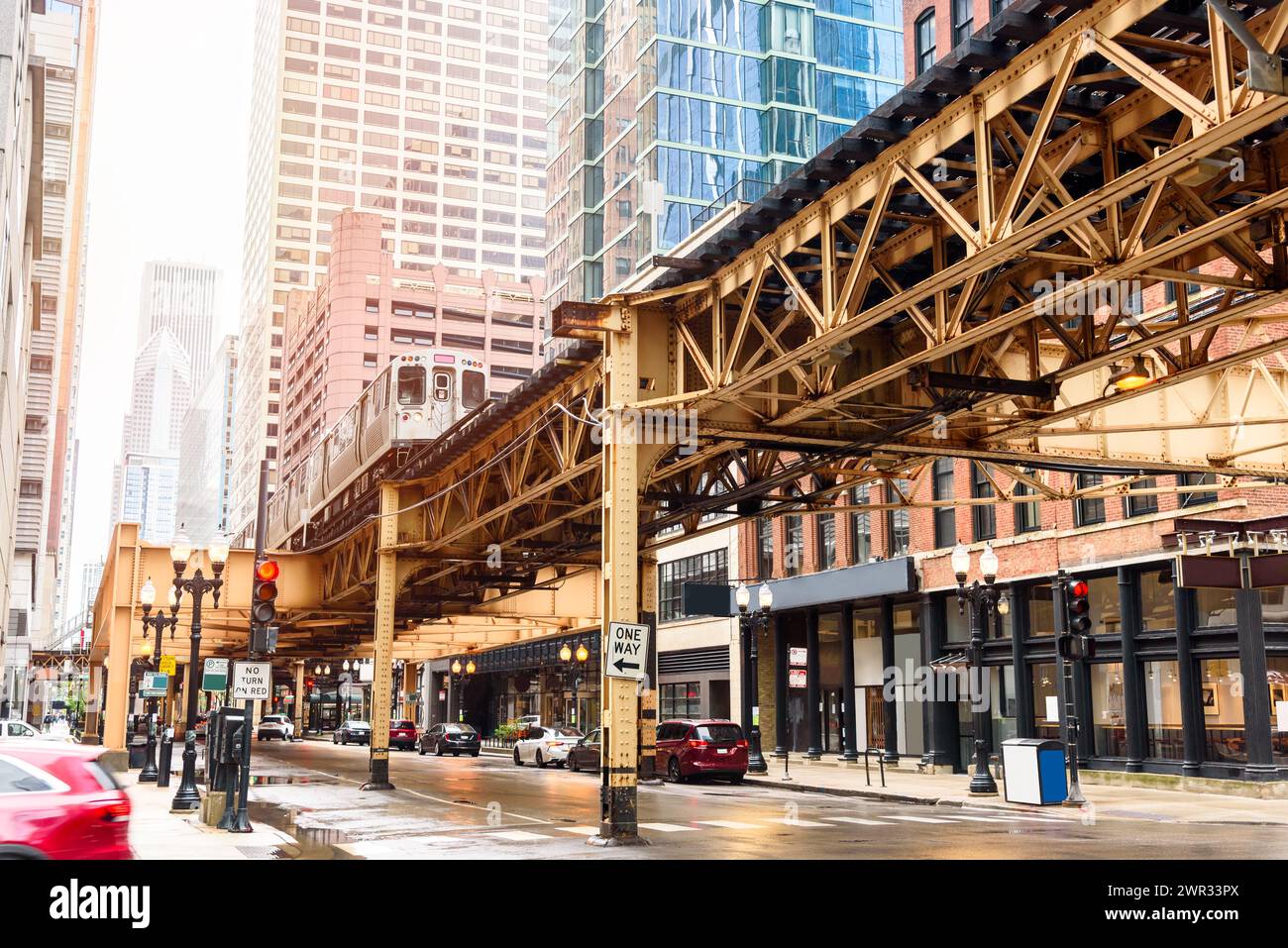 Train running on elevated tracks over a street lined with both modern ...
