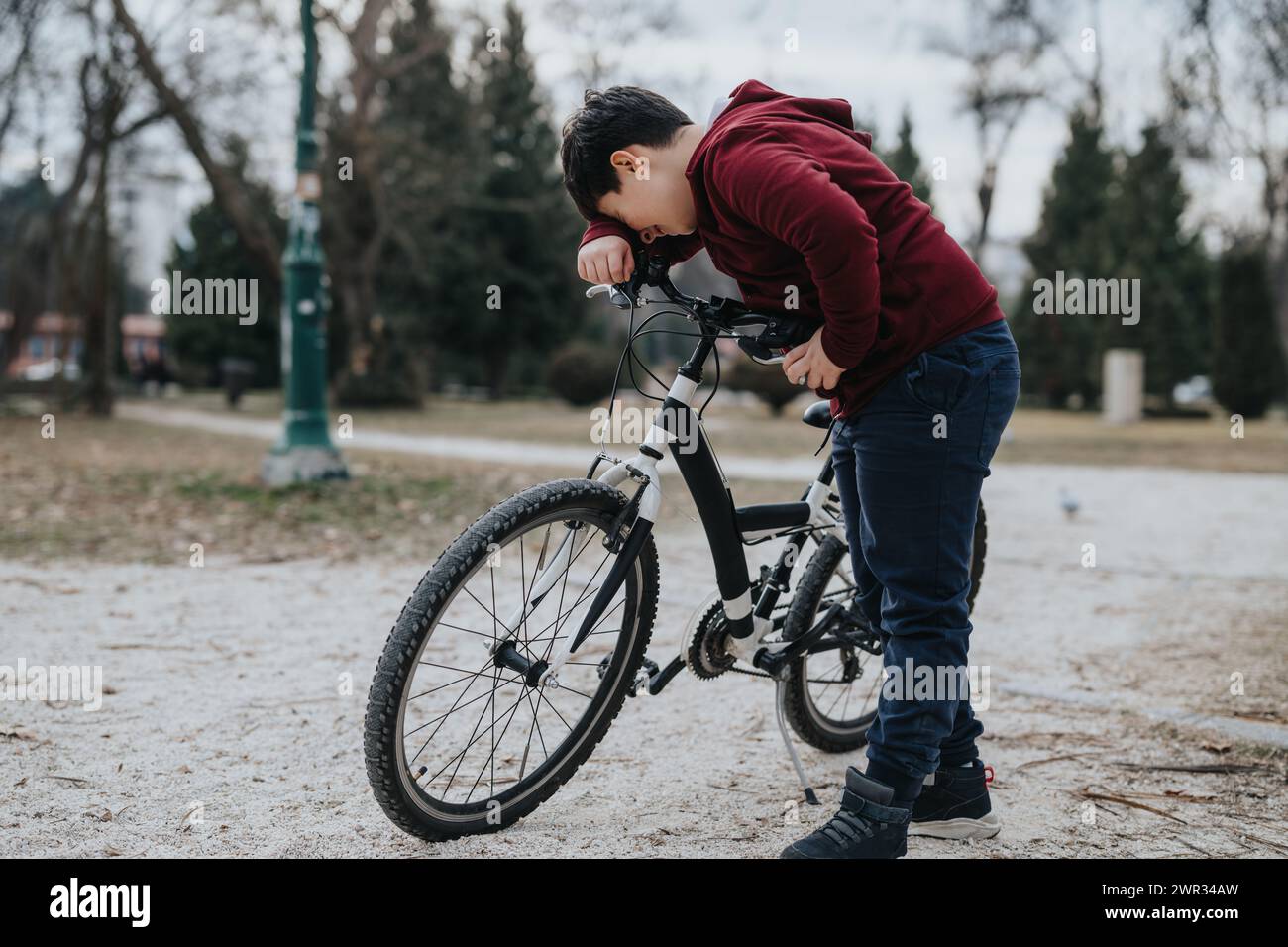 Young boy taking a break while biking in the park outdoors Stock Photo ...