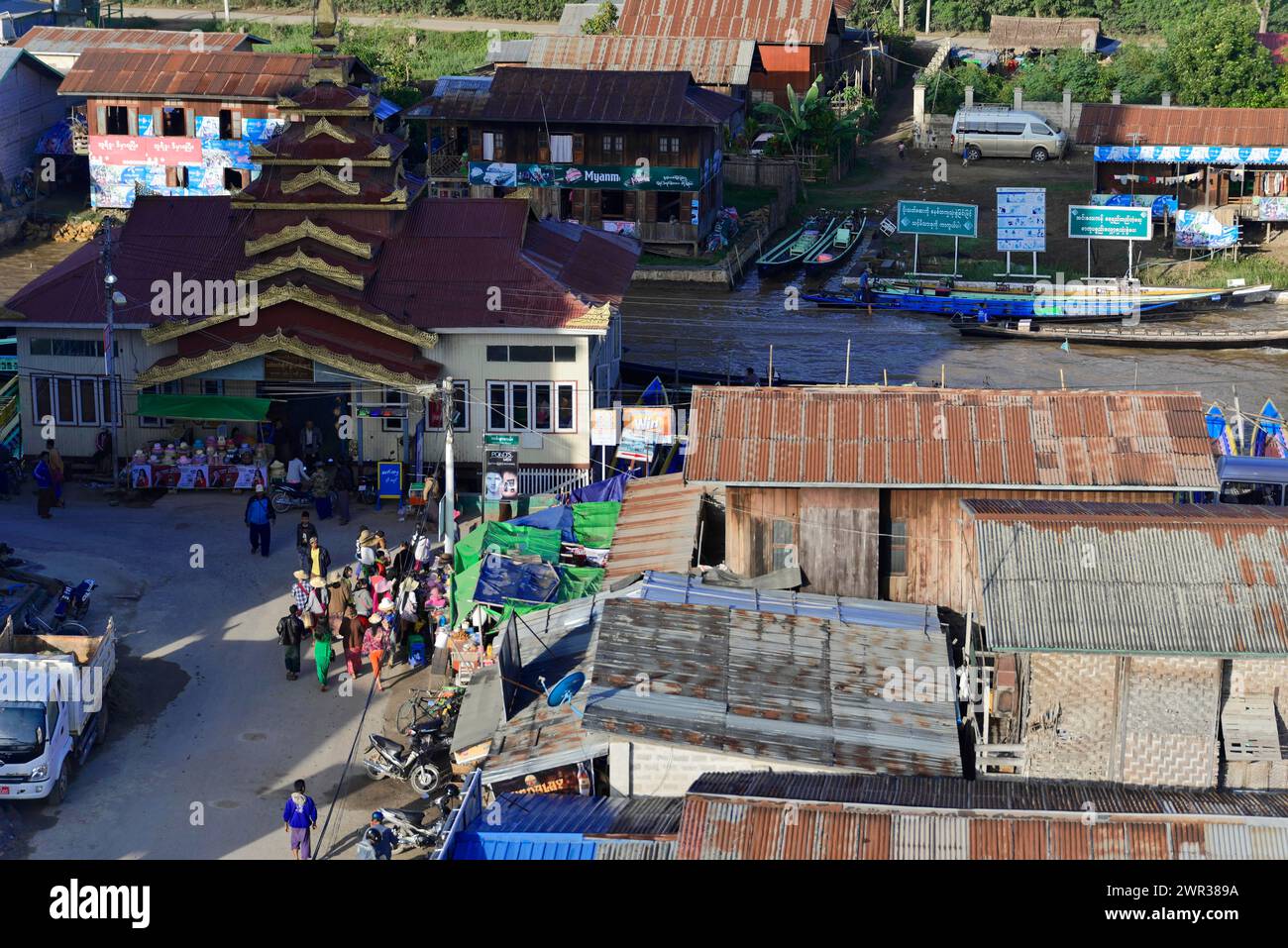 Urban scene with people moving close to buildings and market stalls ...
