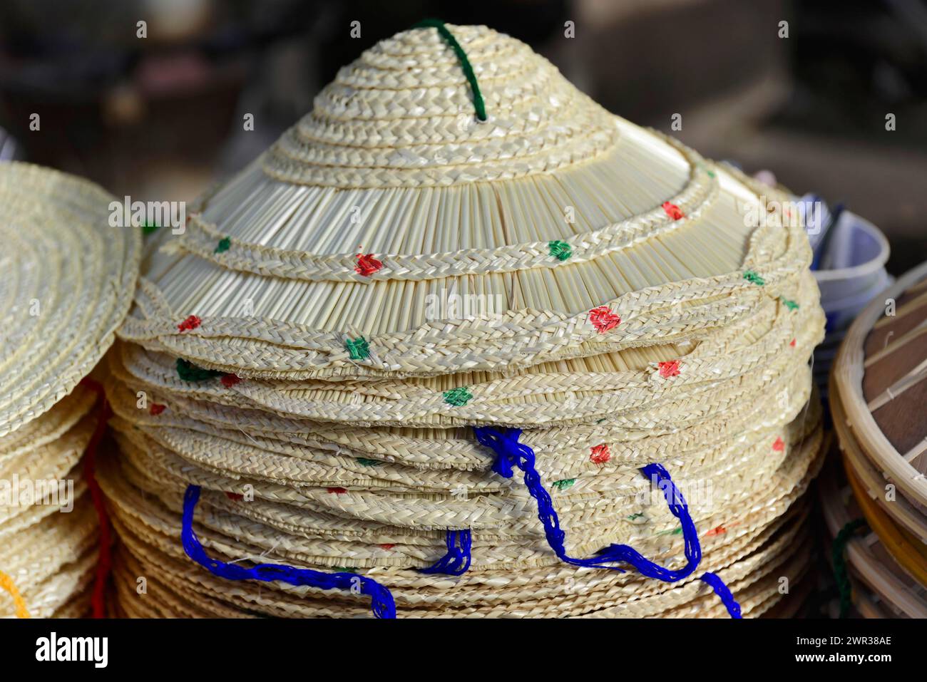 Pile of traditional Asian conical hats, decorated with various patterns ...