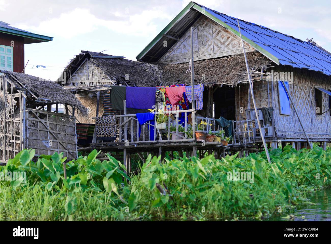Traditional bamboo hut in a floating village with clothesline under a ...