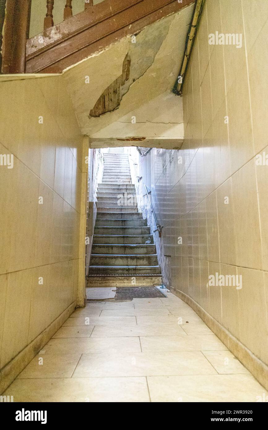 interior of a run-down residential building with stairs leading up to ...