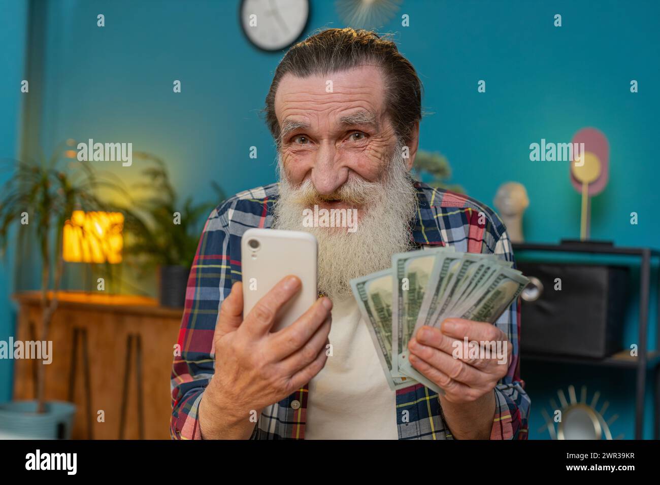 Rich Caucasian senior man counting money while having video call on ...