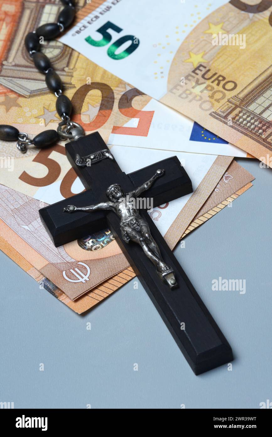 Crucifix and banknotes, church and money, church tax Stock Photo - Alamy