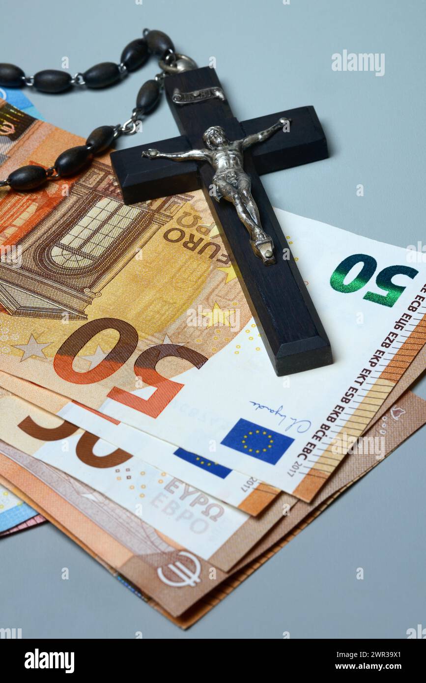 Crucifix and banknotes, church and money, church tax Stock Photo - Alamy
