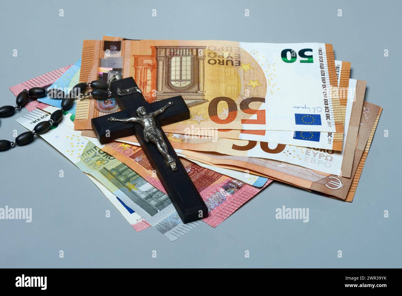 Crucifix and banknotes, church and money, church tax Stock Photo - Alamy