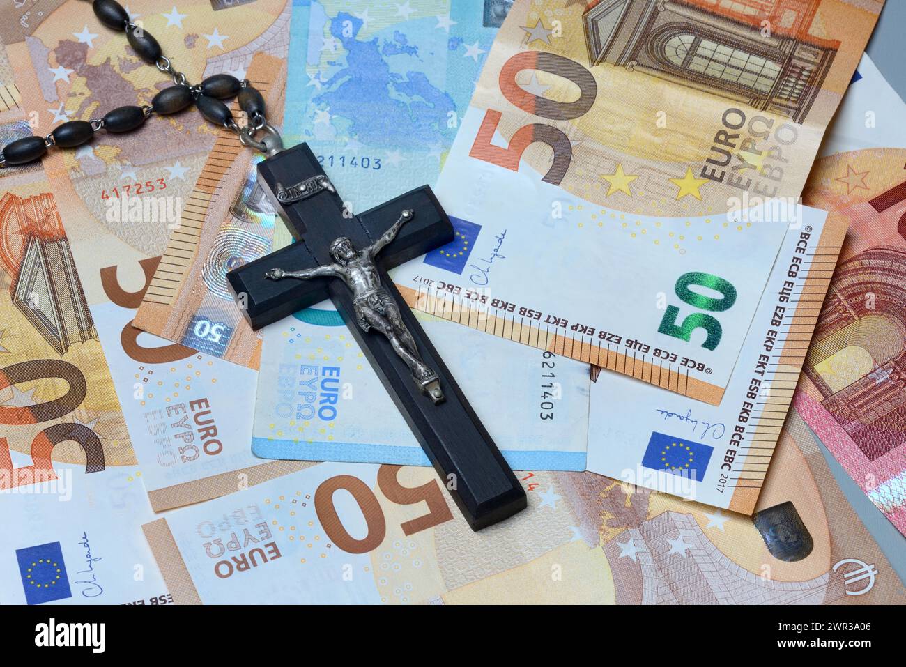 Crucifix and banknotes, church and money, church tax Stock Photo - Alamy
