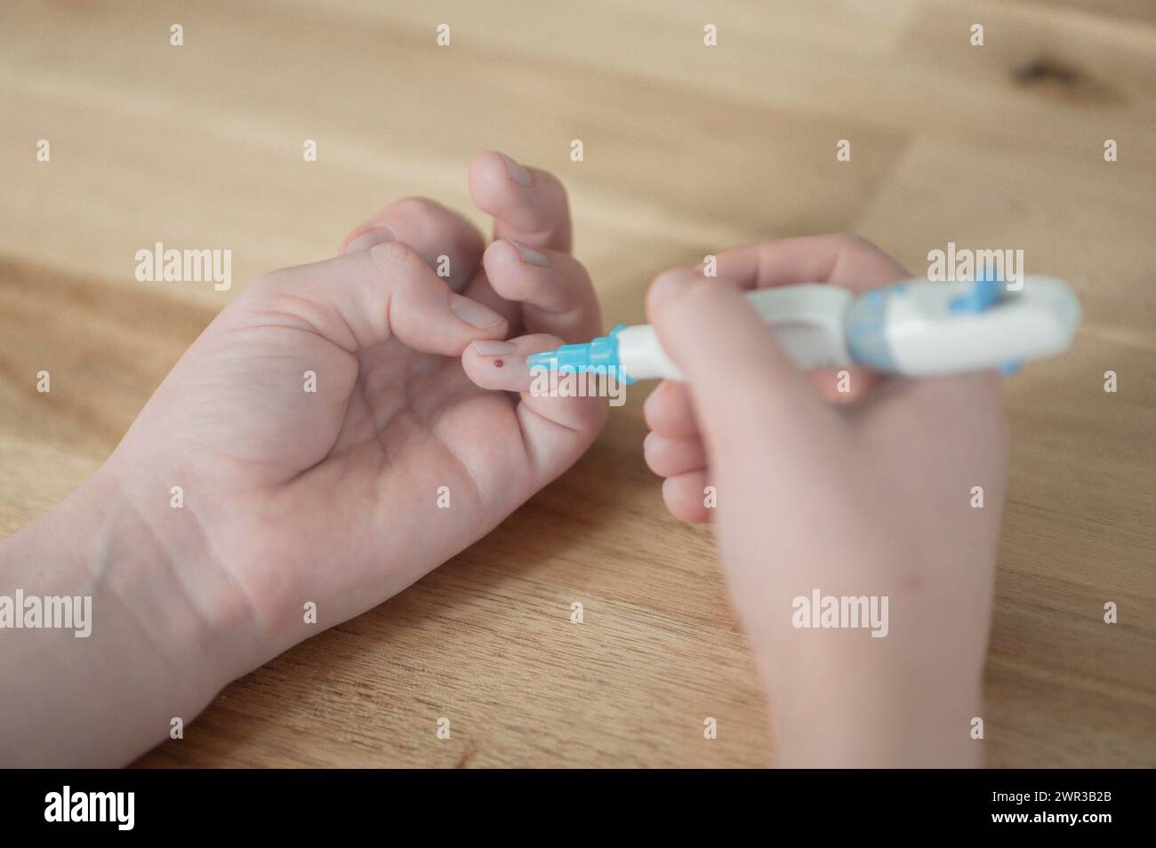 On the left a child's hand with a drop of blood on the little finger ...