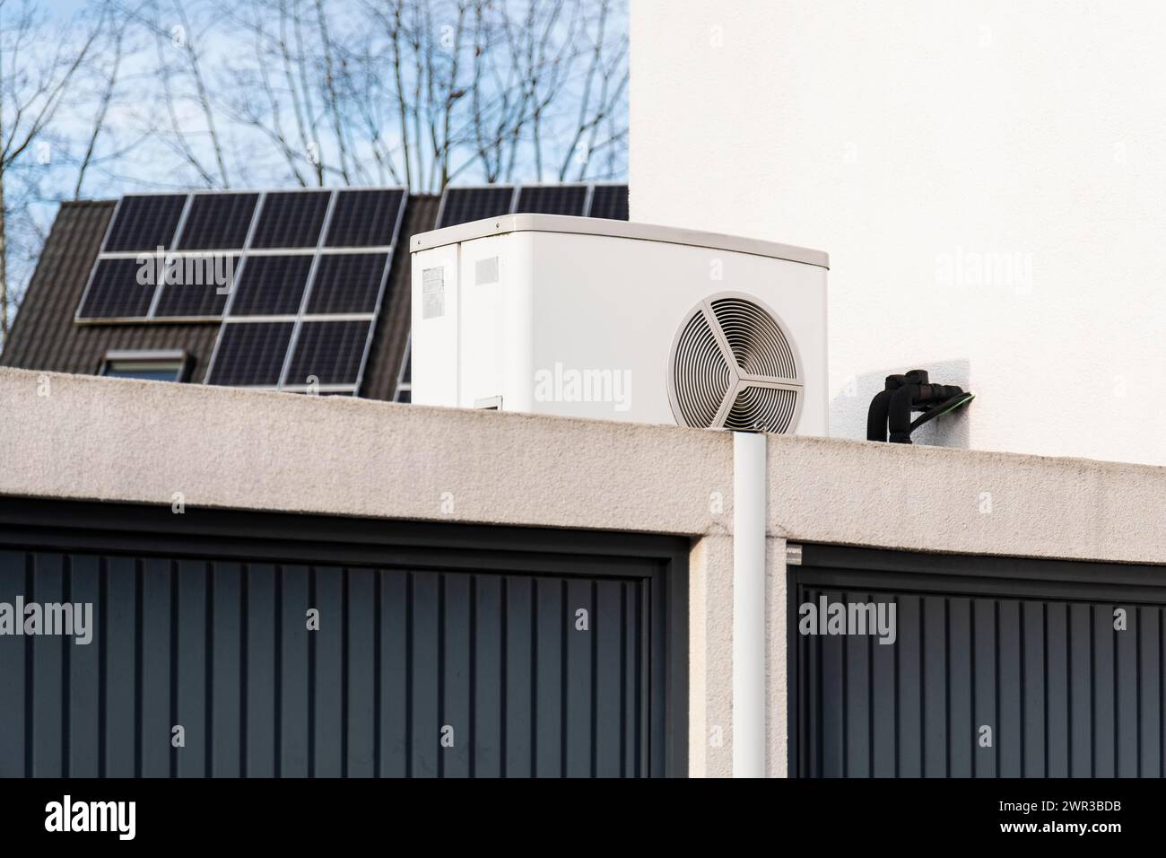 Heat pump on a garage roof of a new development, in the background ...