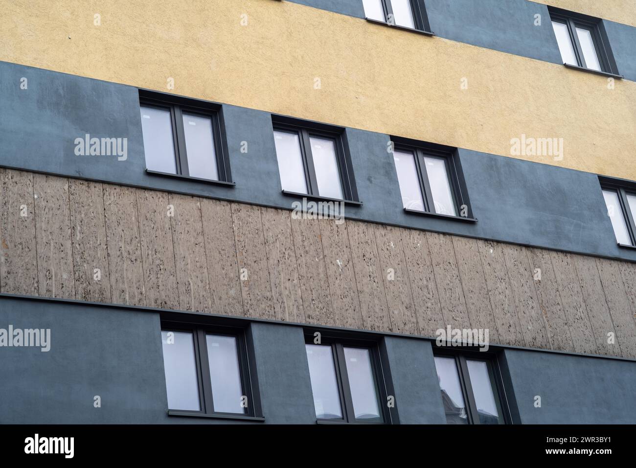 Rows of windows on a yellow-grey building facade, urban environment ...
