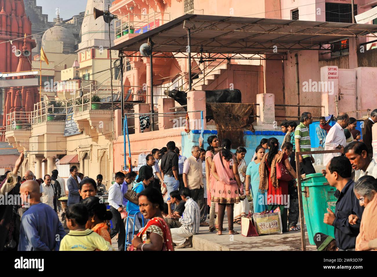 Group of people waiting in a queue on the street next to city buildings ...
