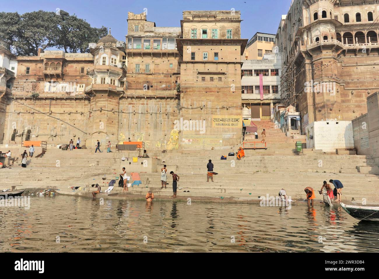 View of a busy stretch of river with urban ghats and historic buildings ...