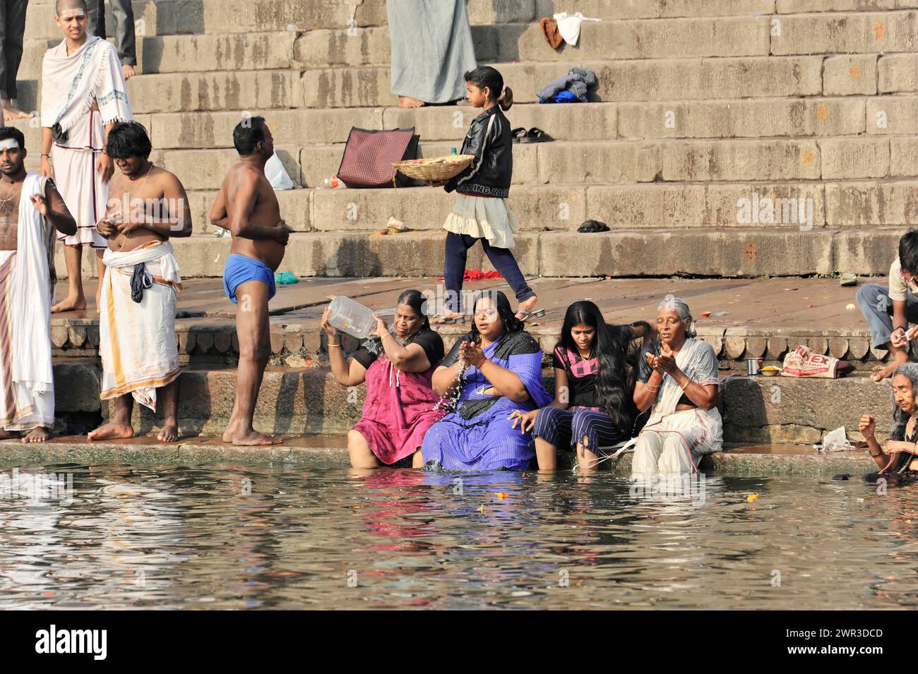 Group of people of different ages in a river during ritual bathing with ...