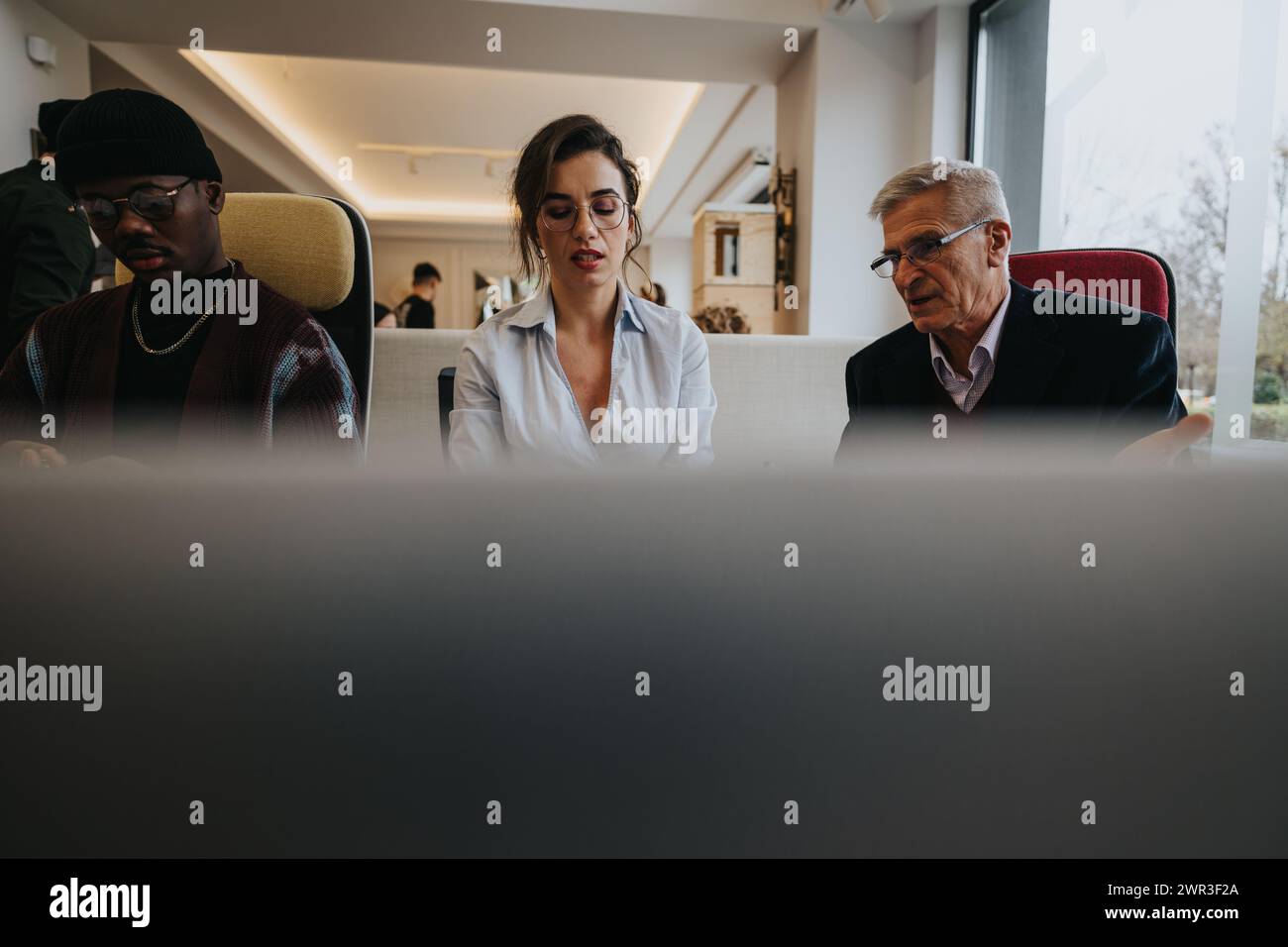 Multi generational, mixed race, business team working together at ...