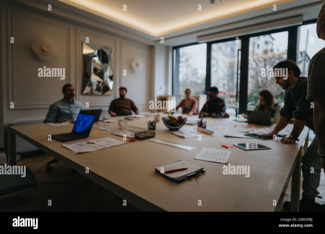 Multi generational colleagues engaged in their tasks in a well-lit ...