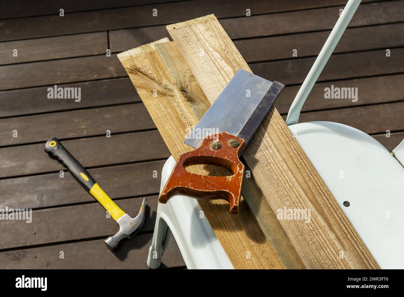 a manual carpentry saw with a wooden handle on some wooden boards and a ...