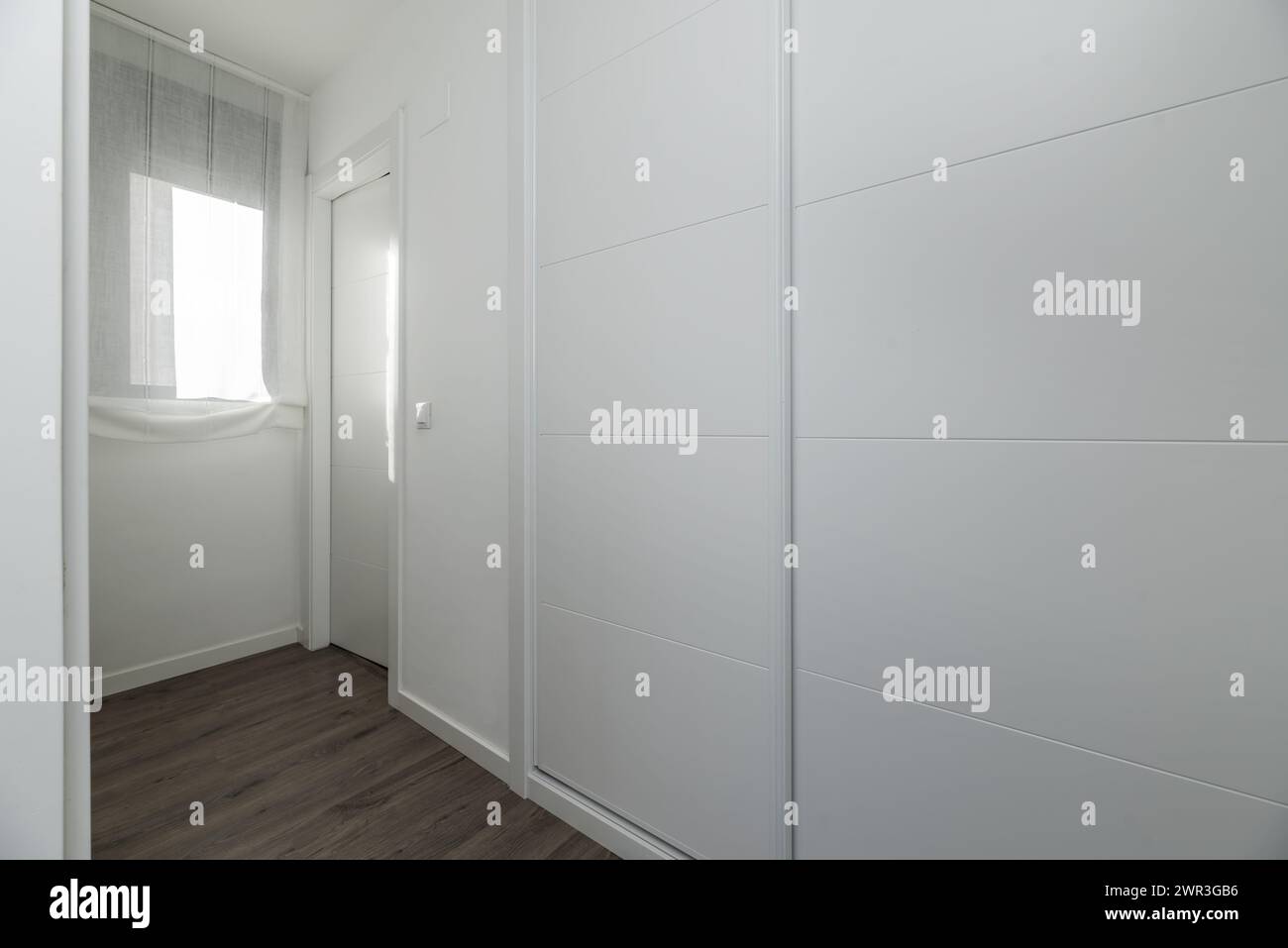 Dressing room in a bedroom with white sliding door closets in a hallway ...