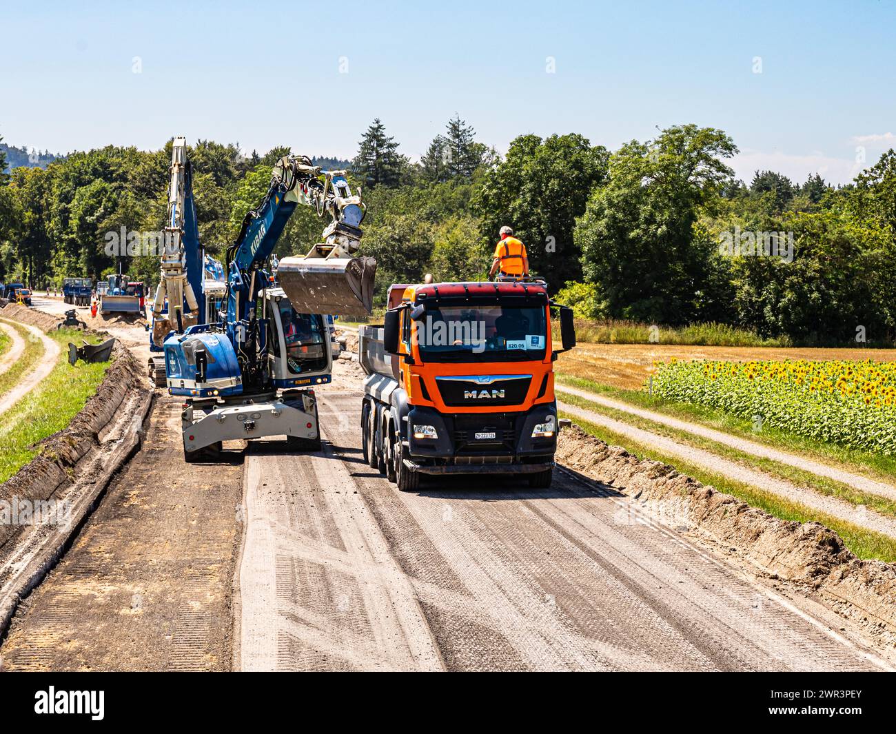 Bagger und weitere schwere Baumaschinen stehen im Einsatz, Lastwagen ...