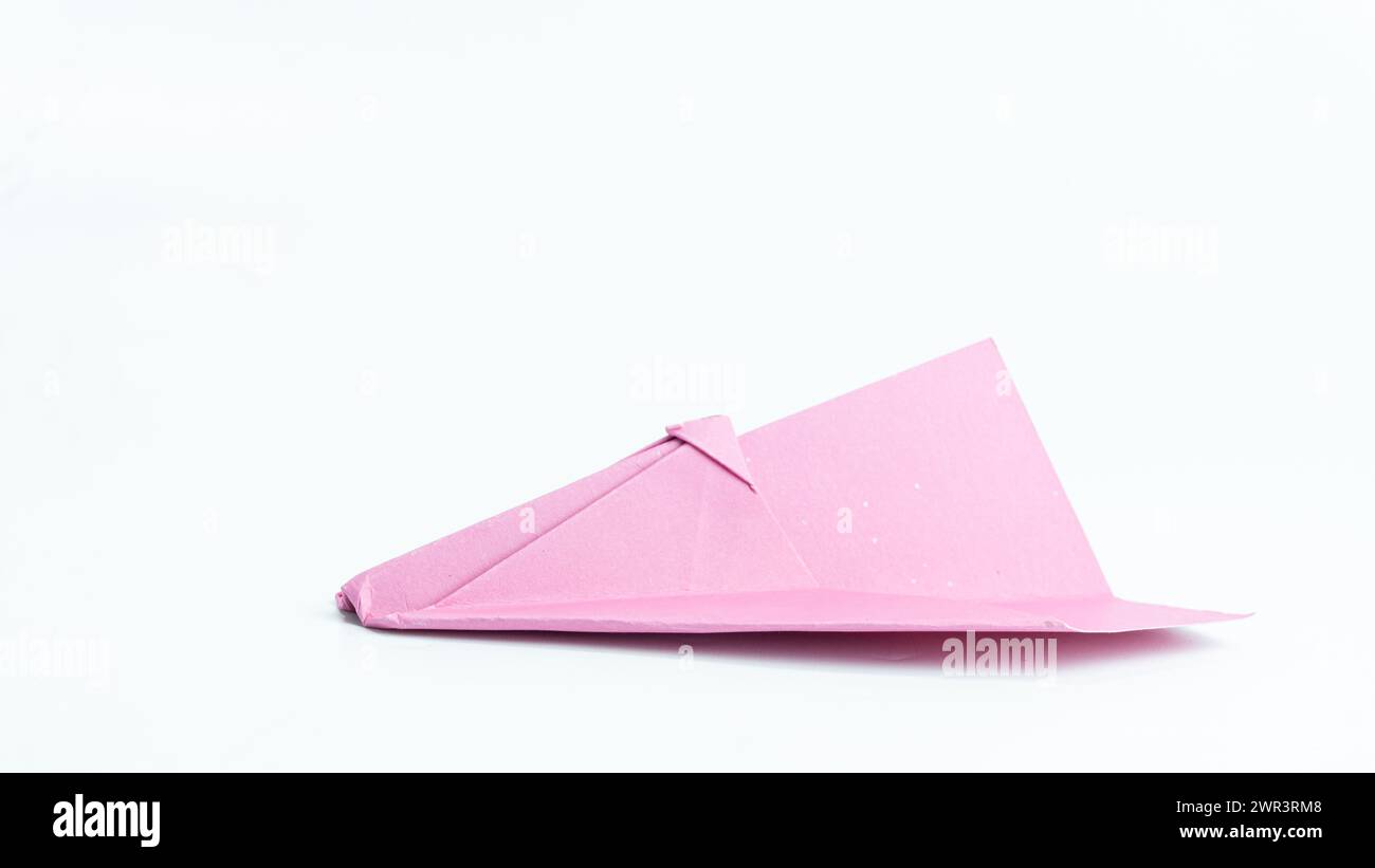 Pink paper airplane isolated on white background Stock Photo - Alamy