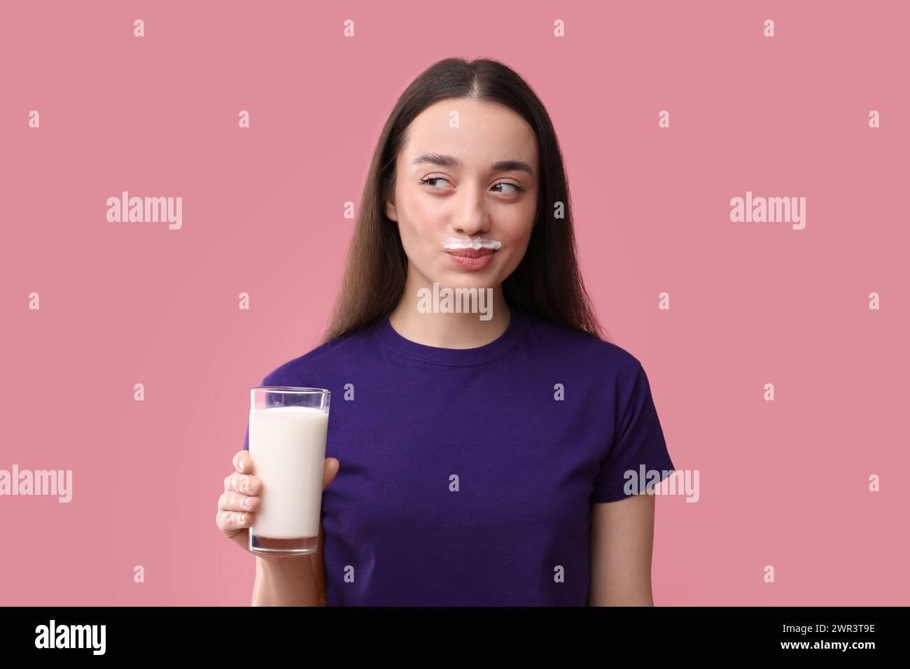 Cute woman with milk mustache holding glass of tasty dairy drink on ...