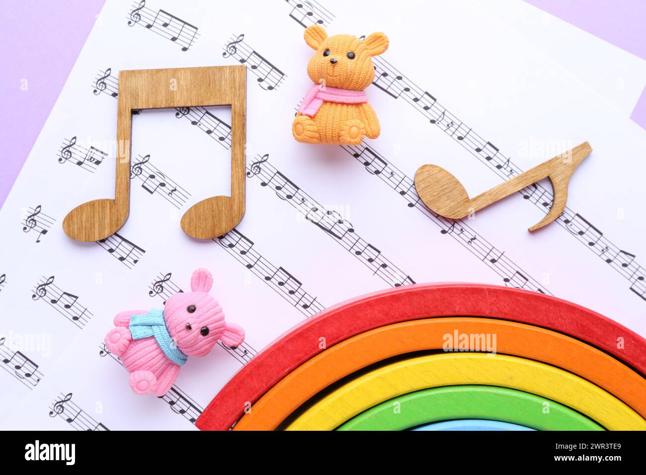 Wooden notes, music sheets and toys on violet background, top view ...