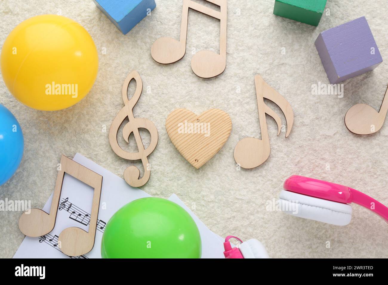 Wooden notes, music sheets and toys on beige textured background, flat ...