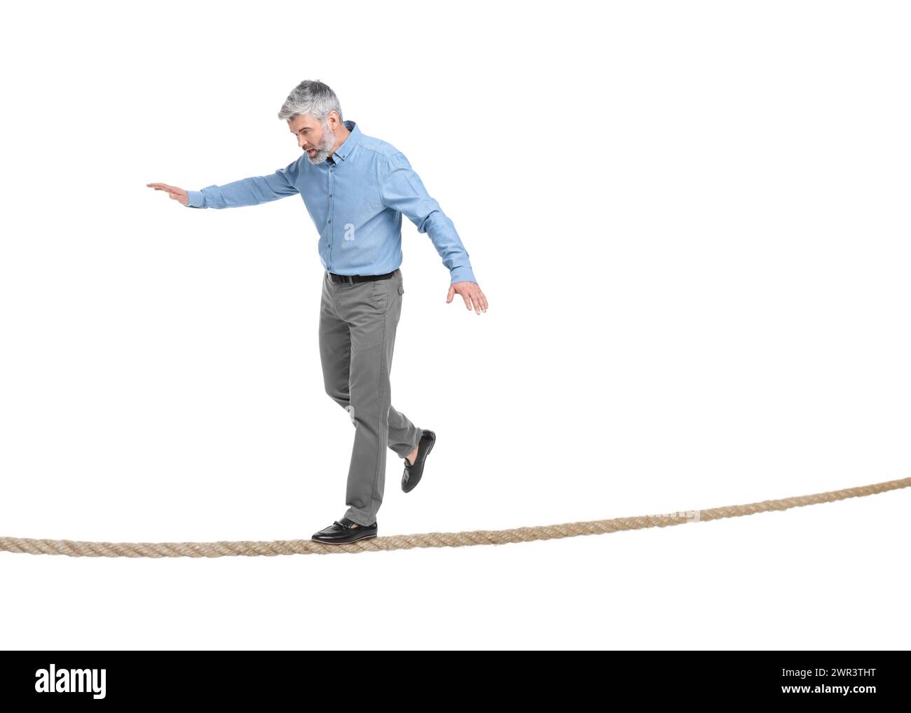 Risks and challenges of owning business. Man balancing on rope against ...