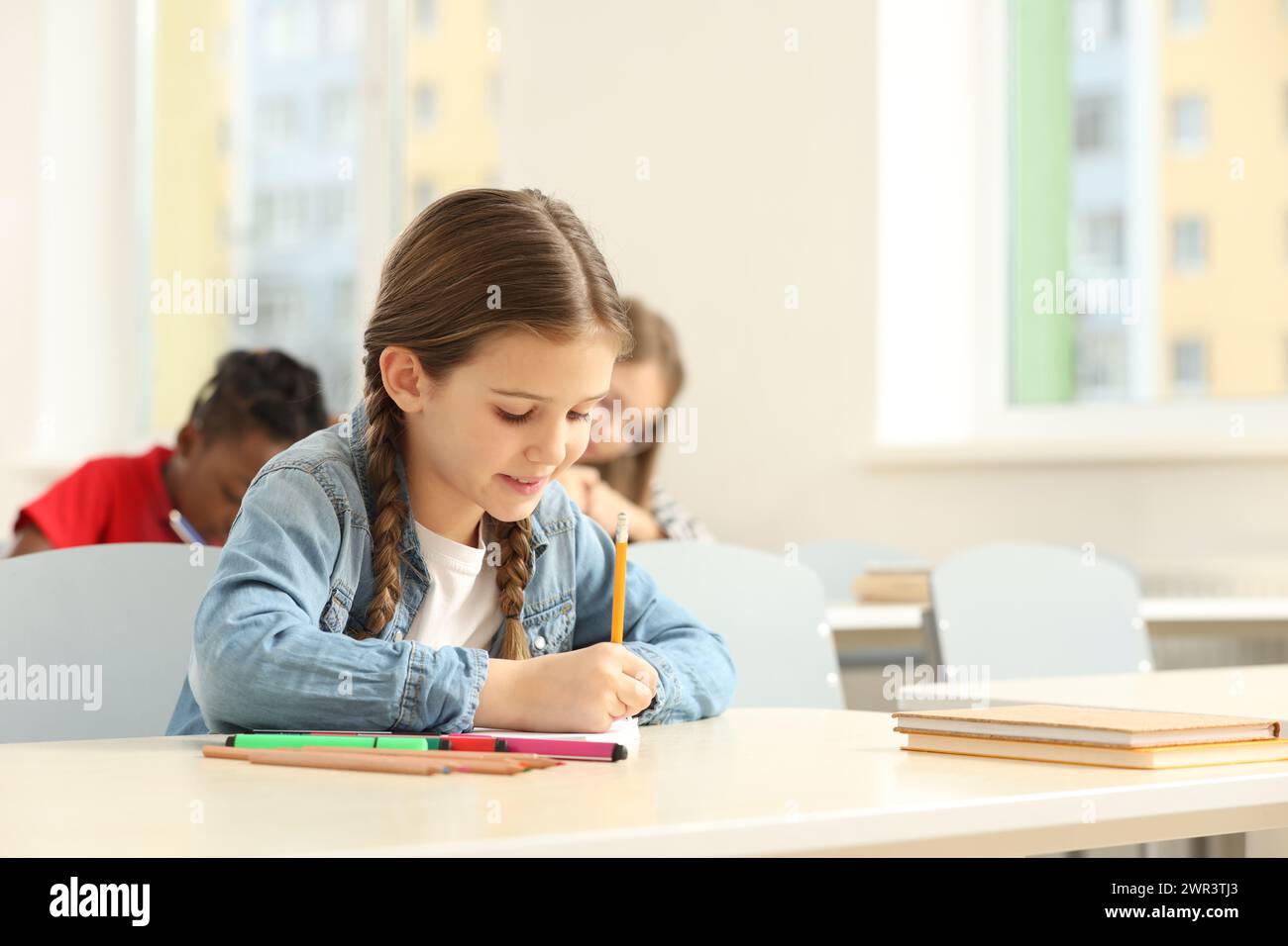 Cute little girl studying in classroom at school. Space for text Stock ...