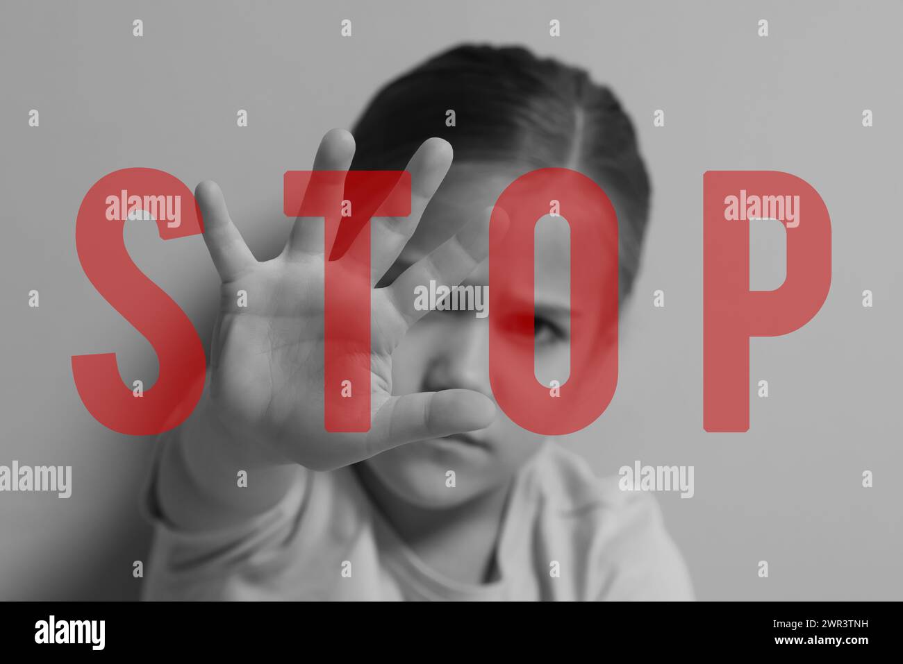 No child abuse. Girl making stop gesture near grey wall, selective ...