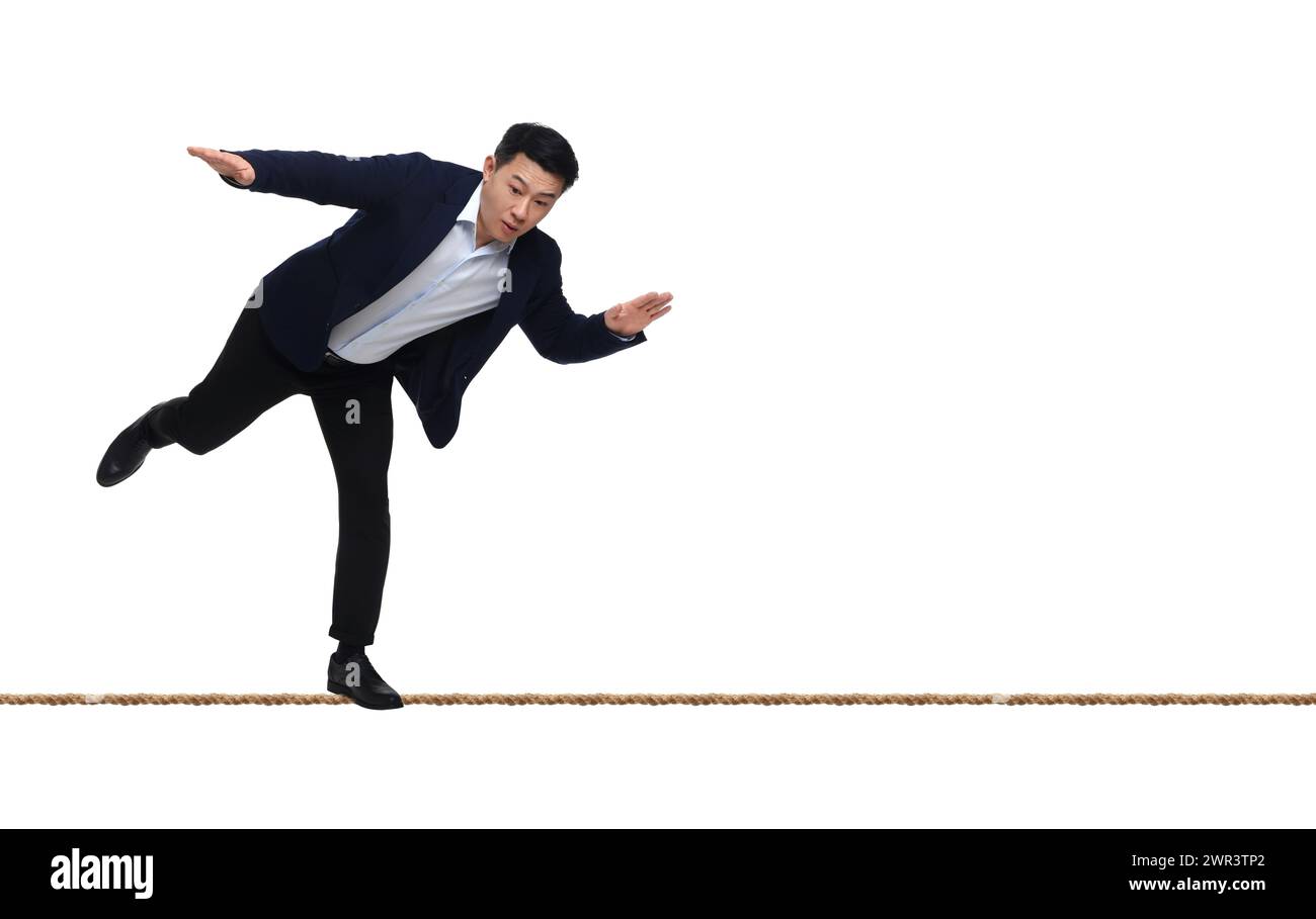 Risks and challenges of owning business. Man balancing on rope against ...