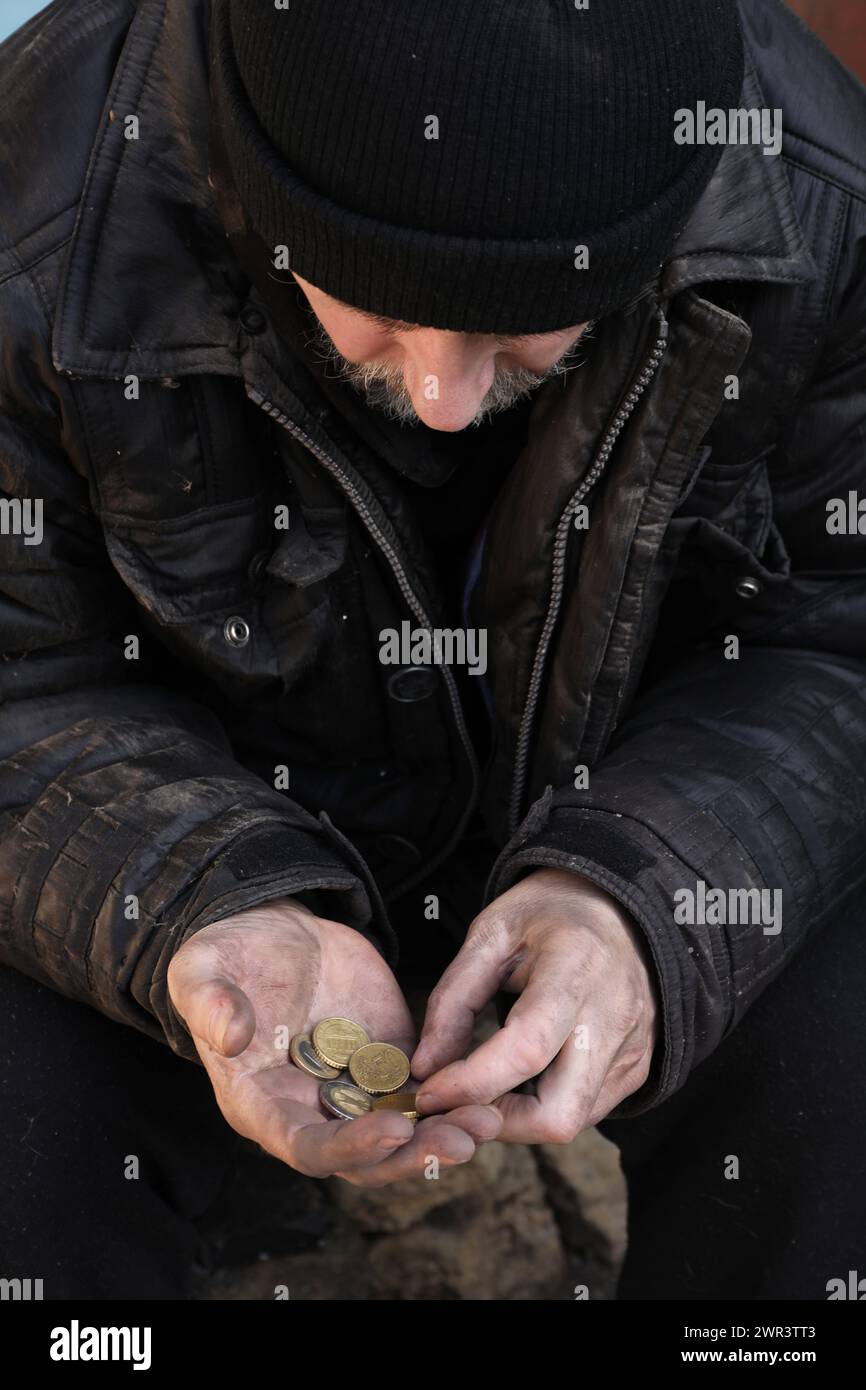 Poor homeless senior man holding coins outdoors Stock Photo - Alamy