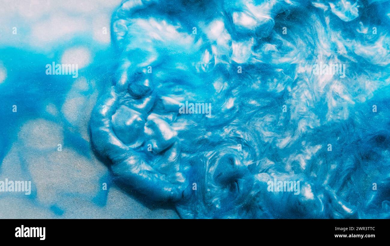 Glitter fluid ink water splash blue paint wave Stock Photo - Alamy