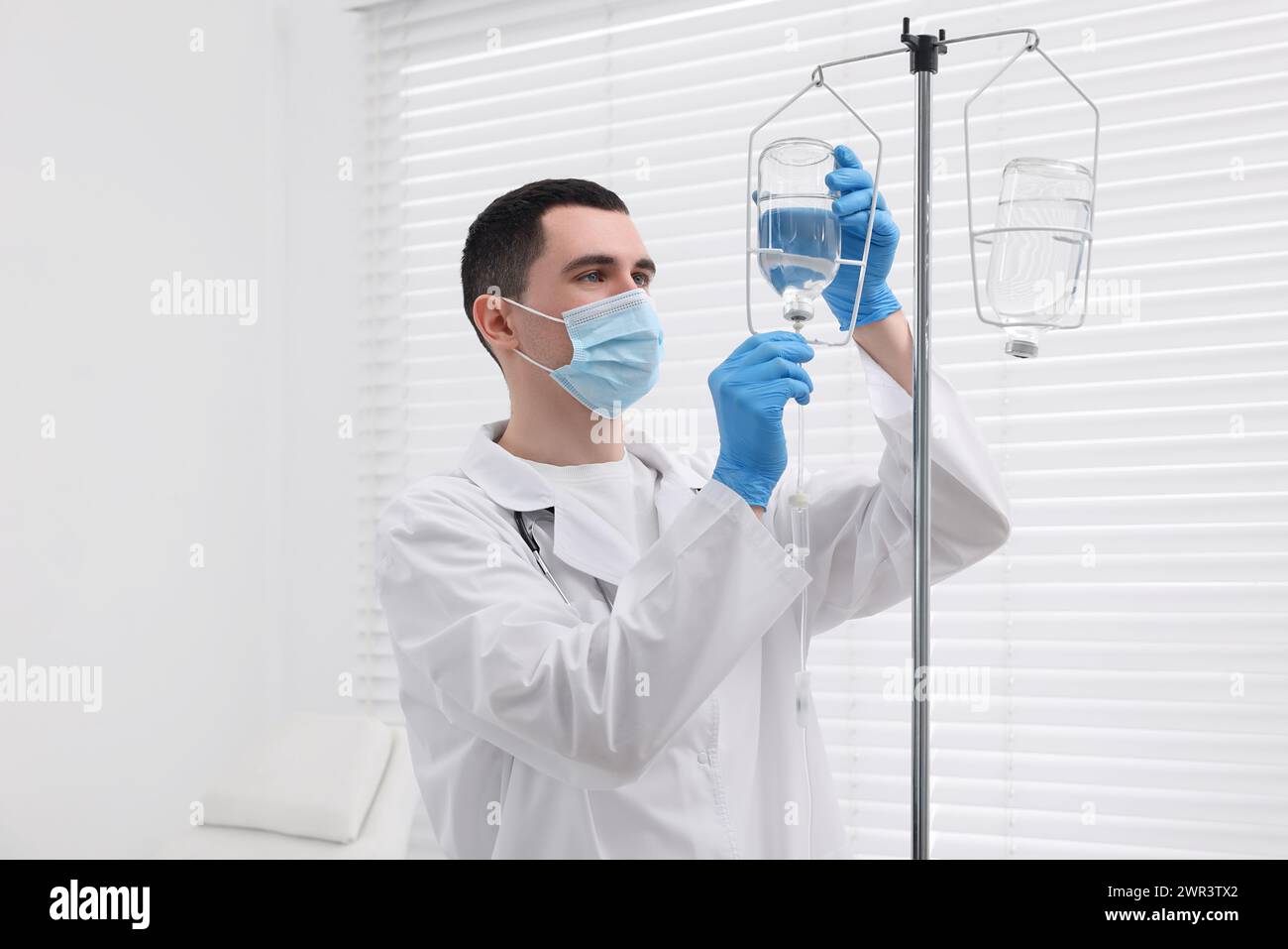 Doctor setting up IV drip in hospital Stock Photo - Alamy