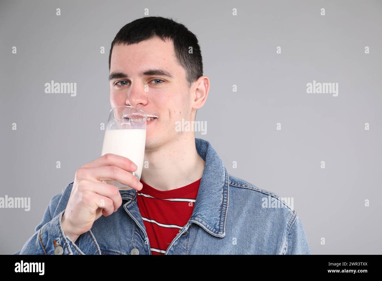 Milk mustache left after dairy product. Man drinking milk on gray ...