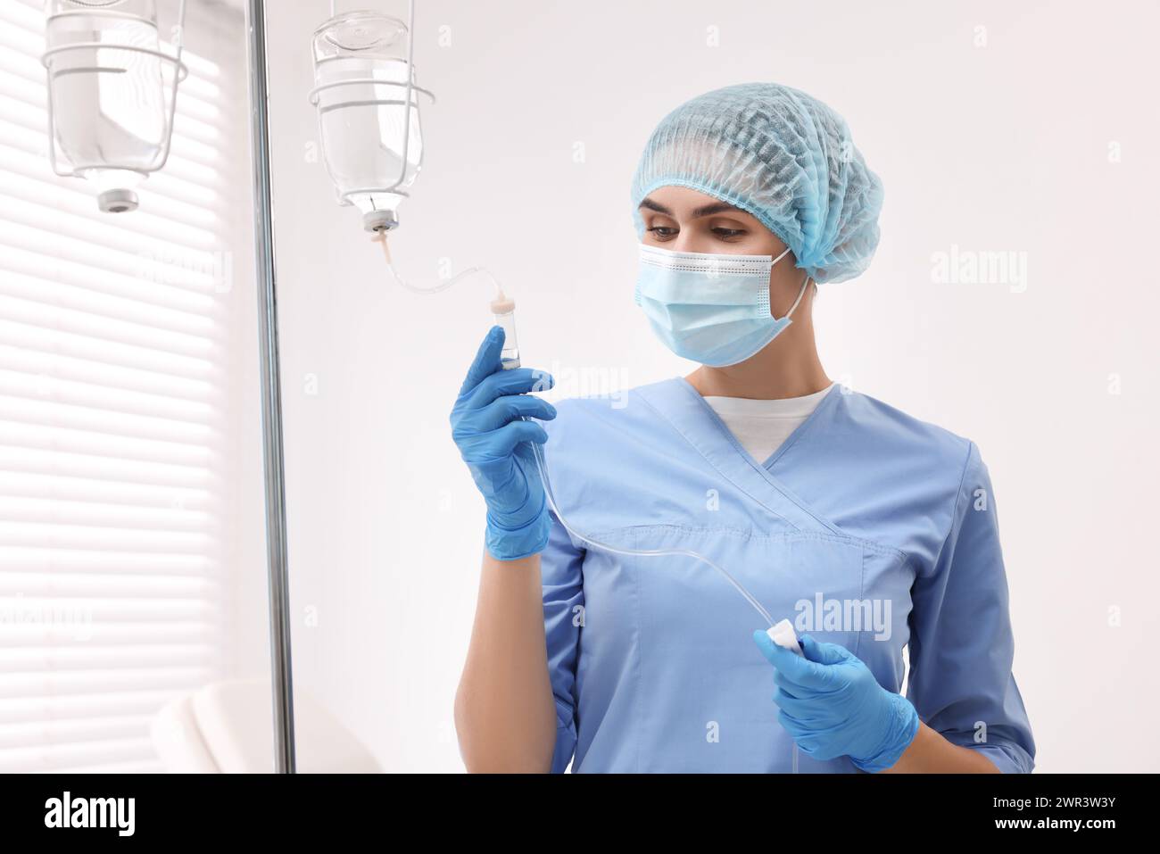 Nurse setting up IV drip in hospital Stock Photo - Alamy