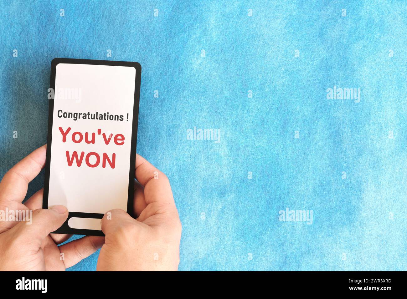 Winning text scam concept. Hand holding mobile phone with ...